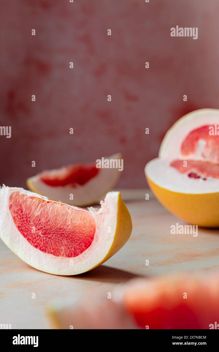 pink sliced pomelo on a pink background Stock Photo - Alamy