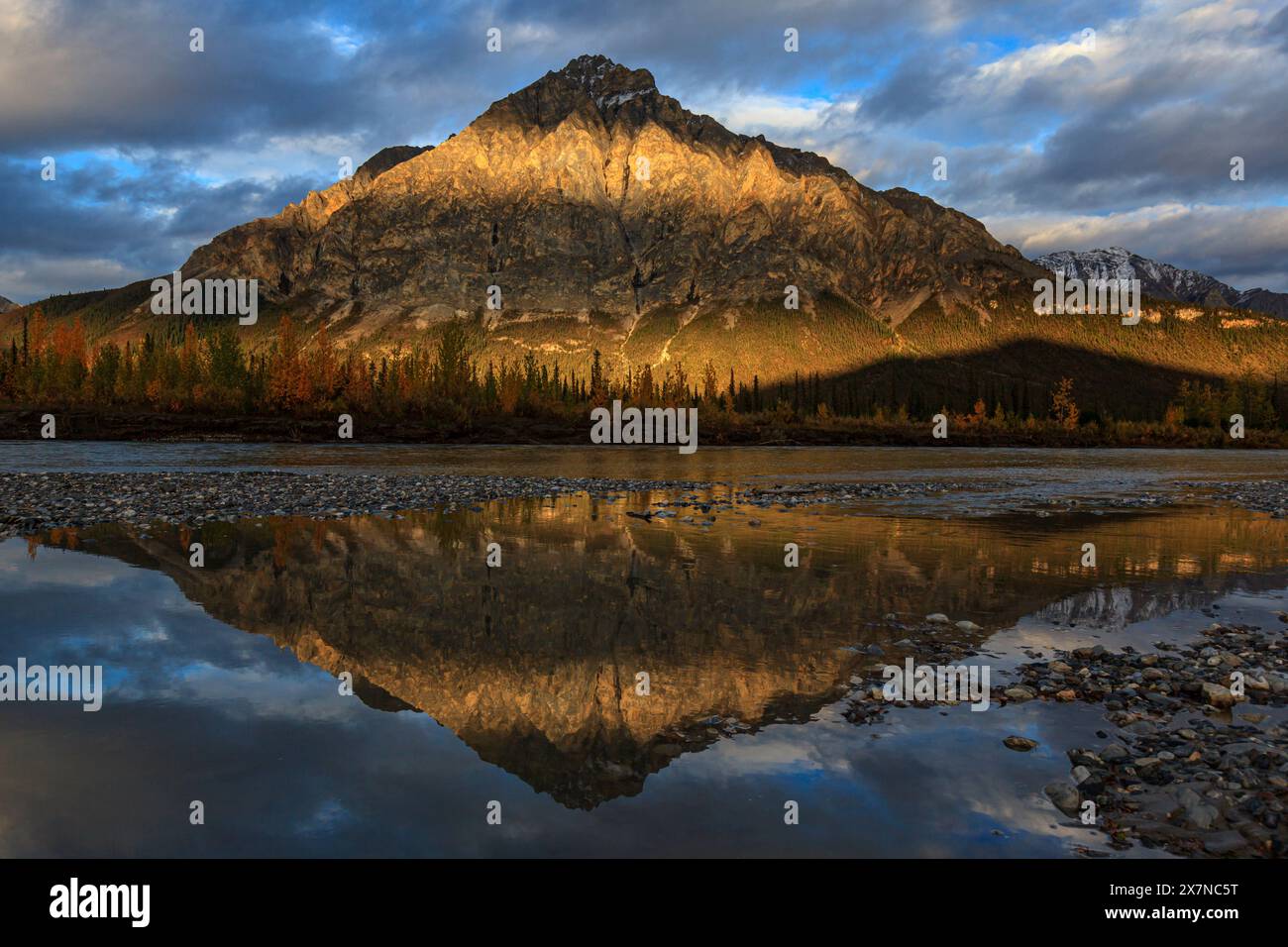 Evening light, reflection of steep mountain in water, Brooks Range ...