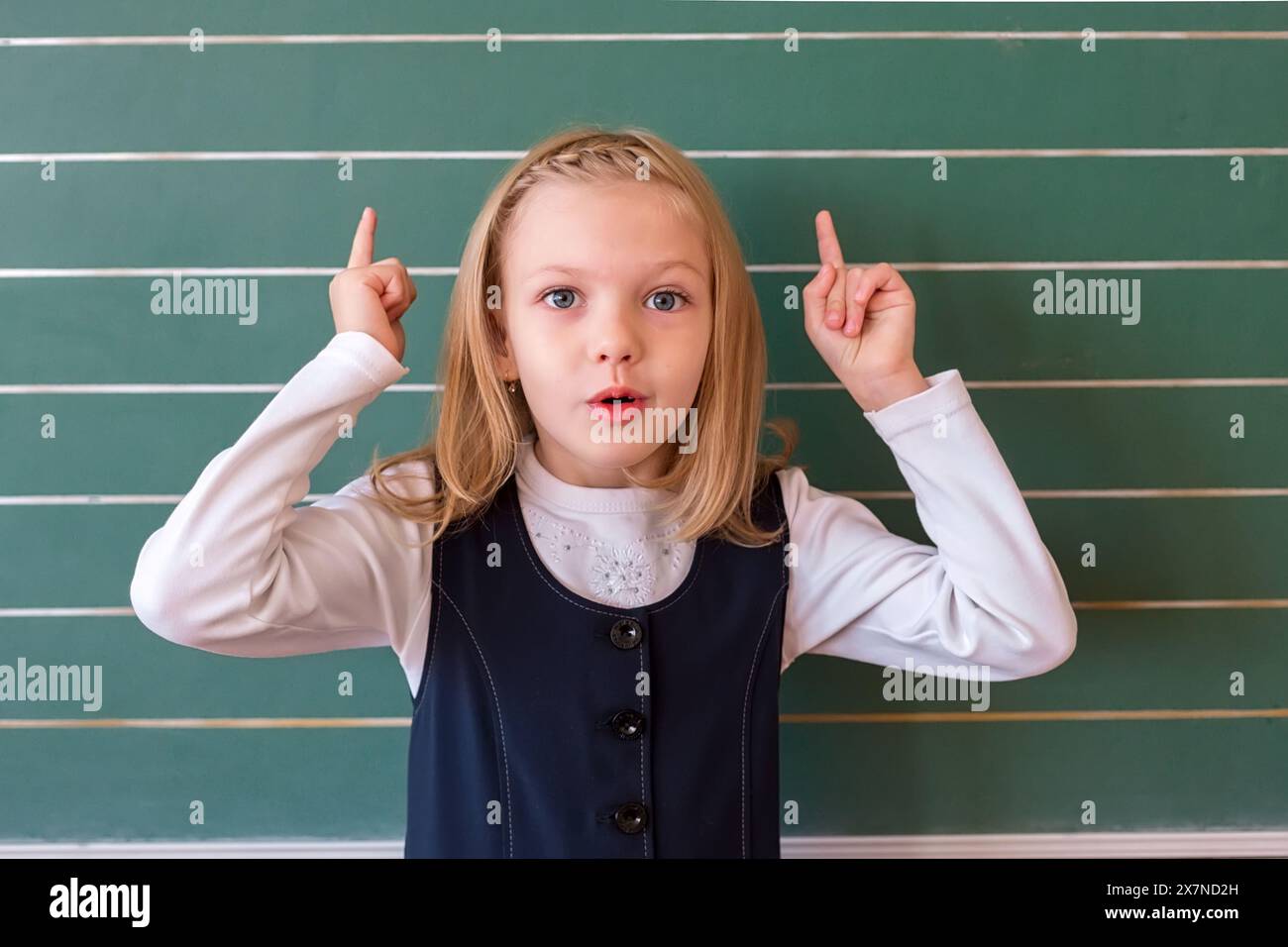 a small beauty of a first grade student at a school near the board ...