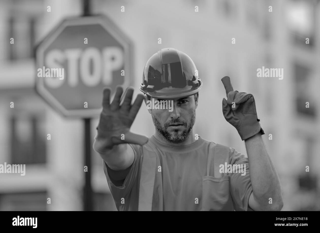 Serious engineer with stop road sign. Builder with stop gesture, no ...