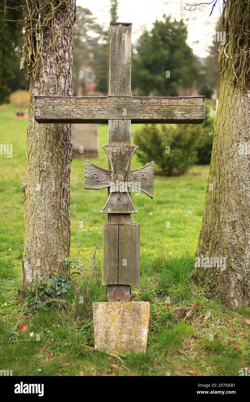 Ancient and weathered wooden cross on a cemetery in Germany, with an ...