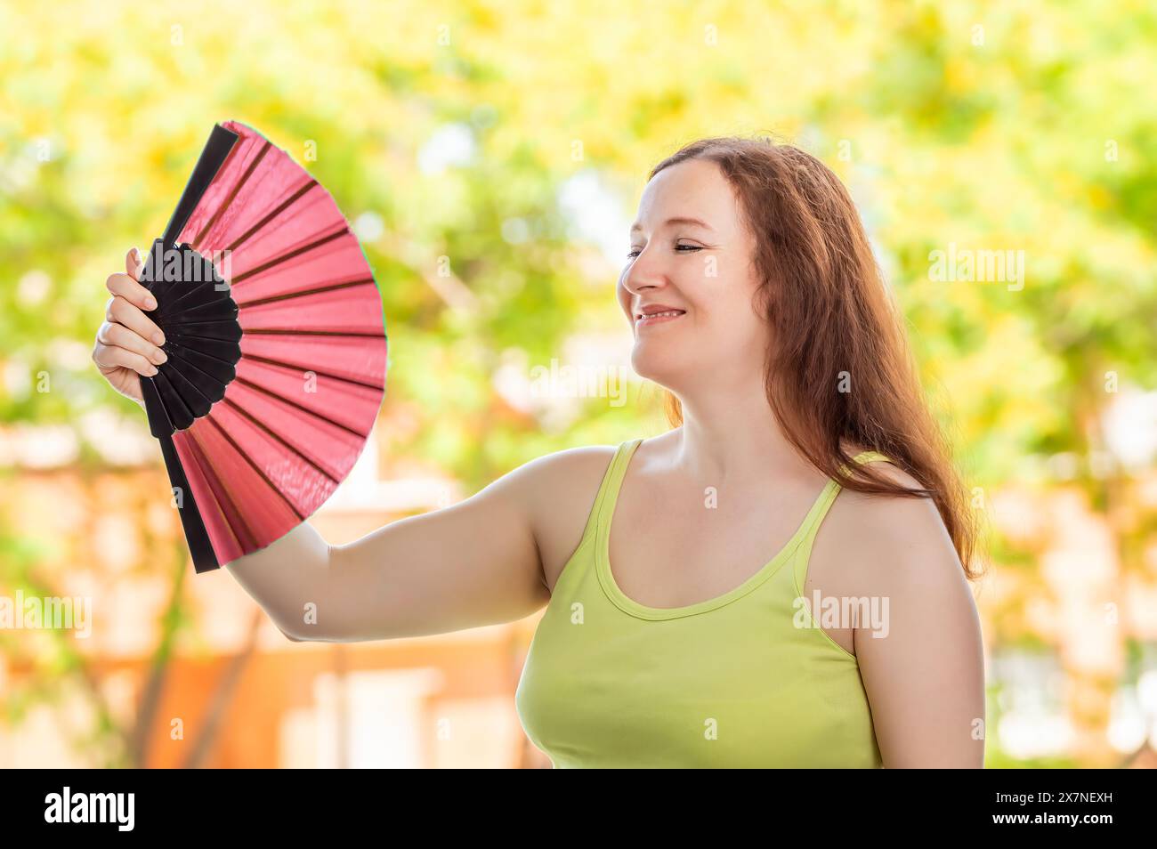 Sad woman fanning and sweating suffering a heat stroke in a park Stock ...
