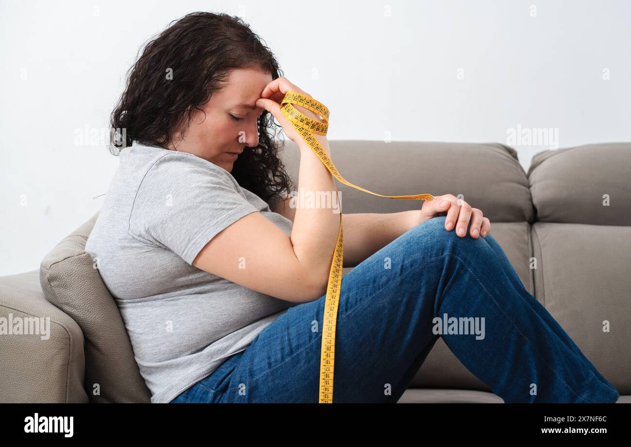 Sad woman obsessed with diet complaining sitting in couch at home Stock ...
