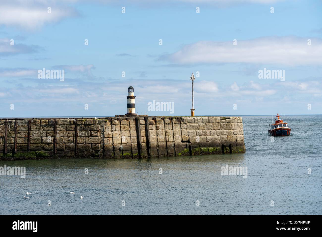 Seaham, County Durham, UK. A view of the lighthouse and harbour walls ...