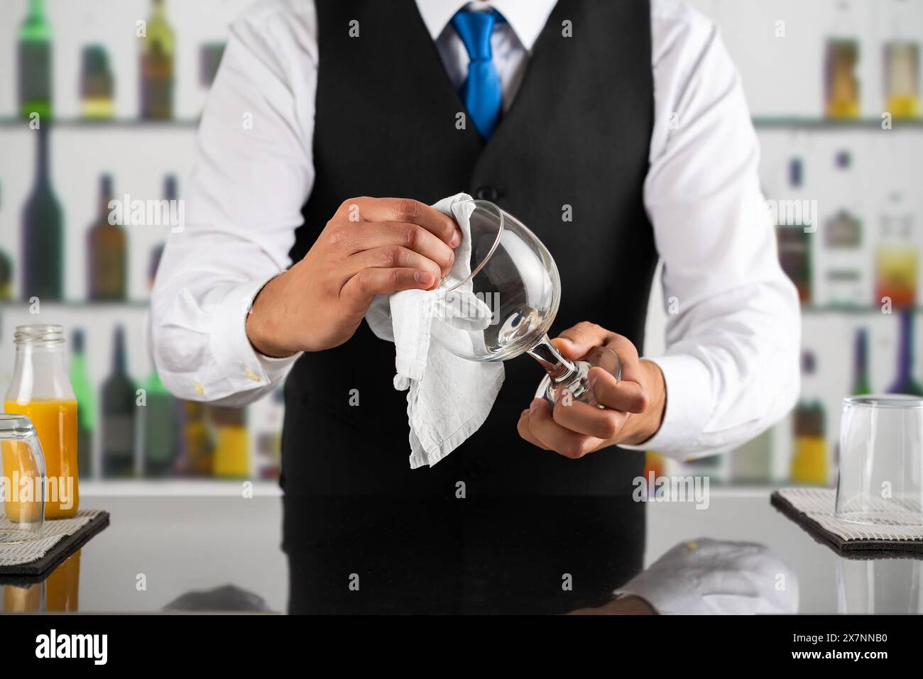 Shot of a happy waiter polishing a glass behind the bar Stock Photo - Alamy