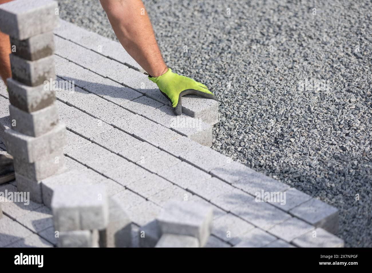 Process of building sidewalk, worker laying interlocking walking path ...