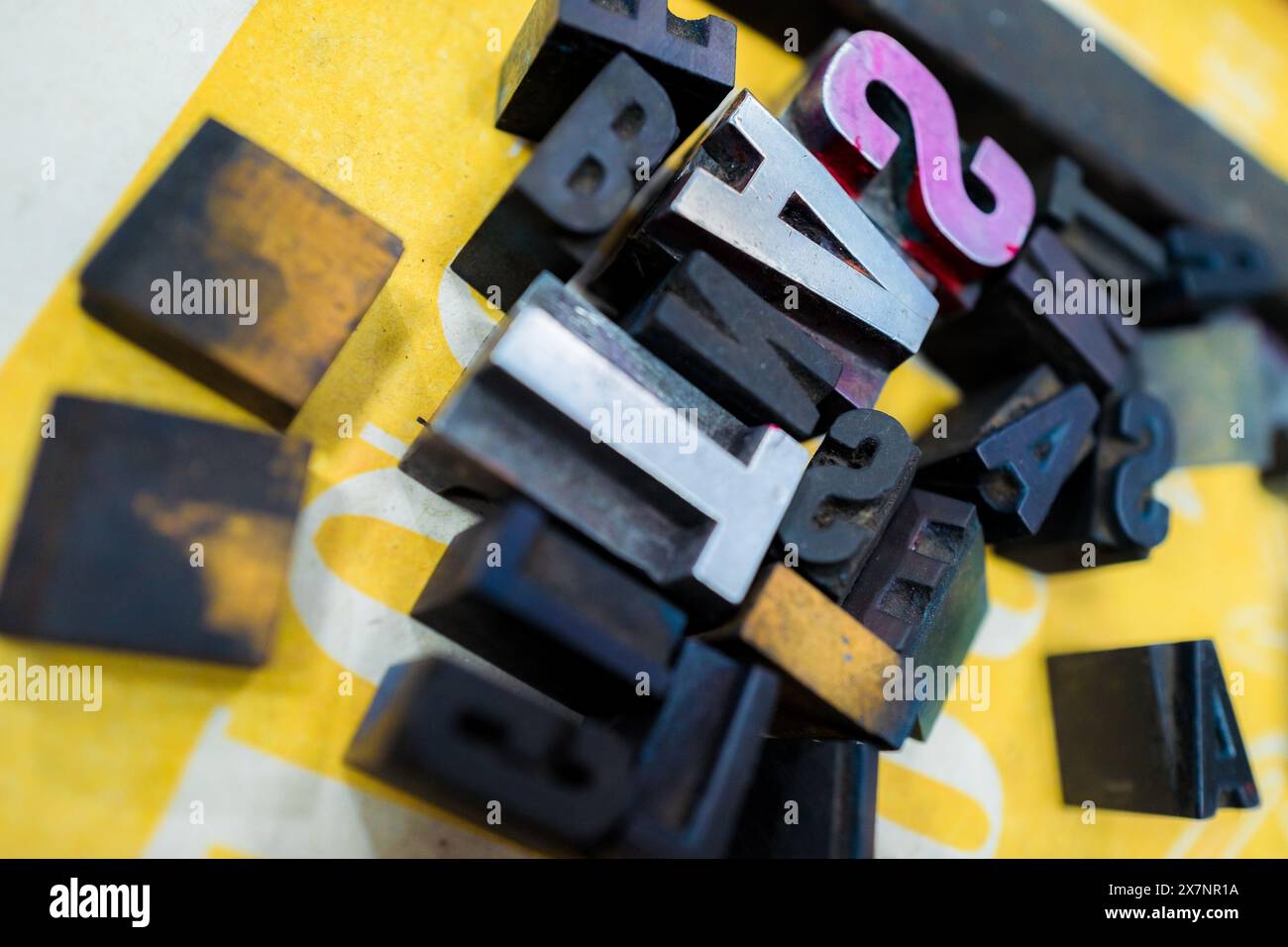 The movable letterpress types are seen randomly placed on the work ...