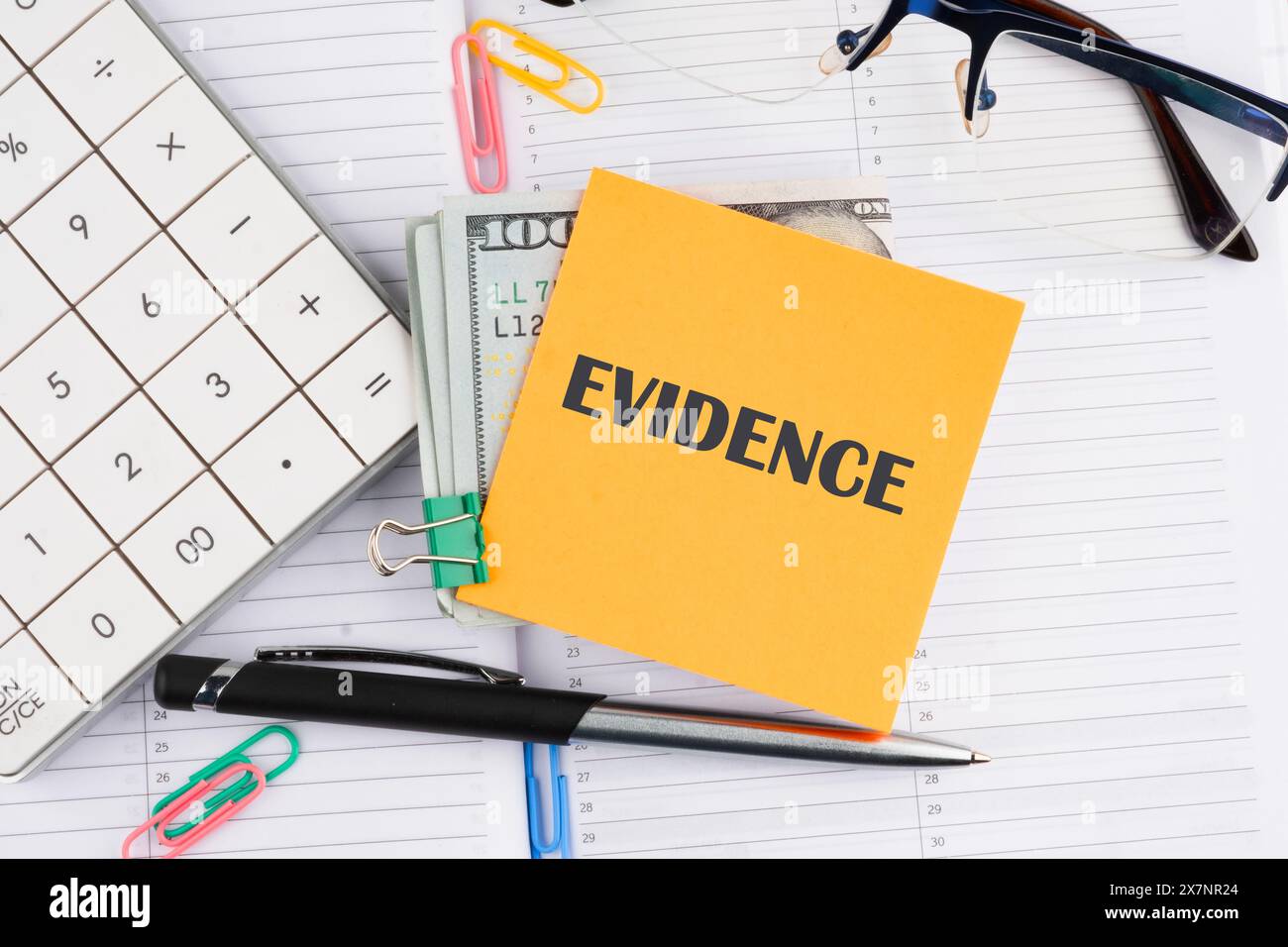 Word EVIDENCE composed on a yellow sticker with money on a business ...