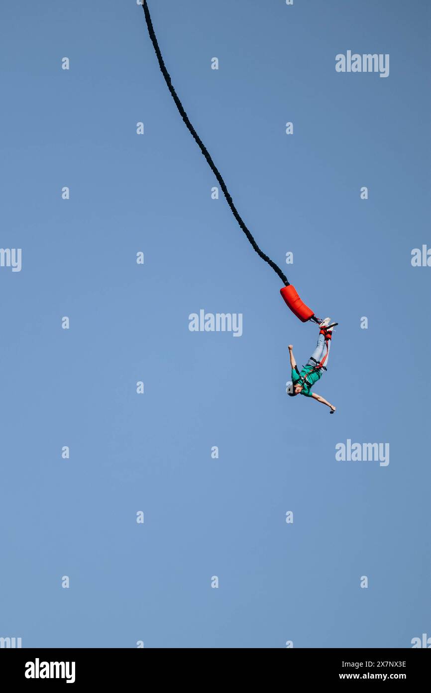 Bungee jumping from a great height while connected to a large elastic ...
