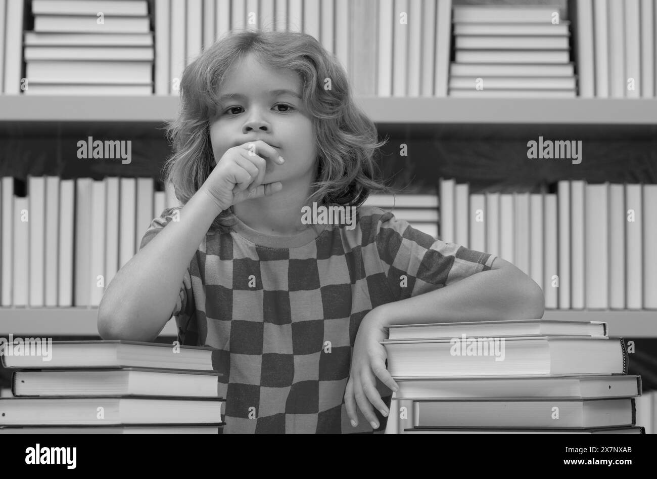 Elementary schoolboy. School boy doing homework on desk in school ...