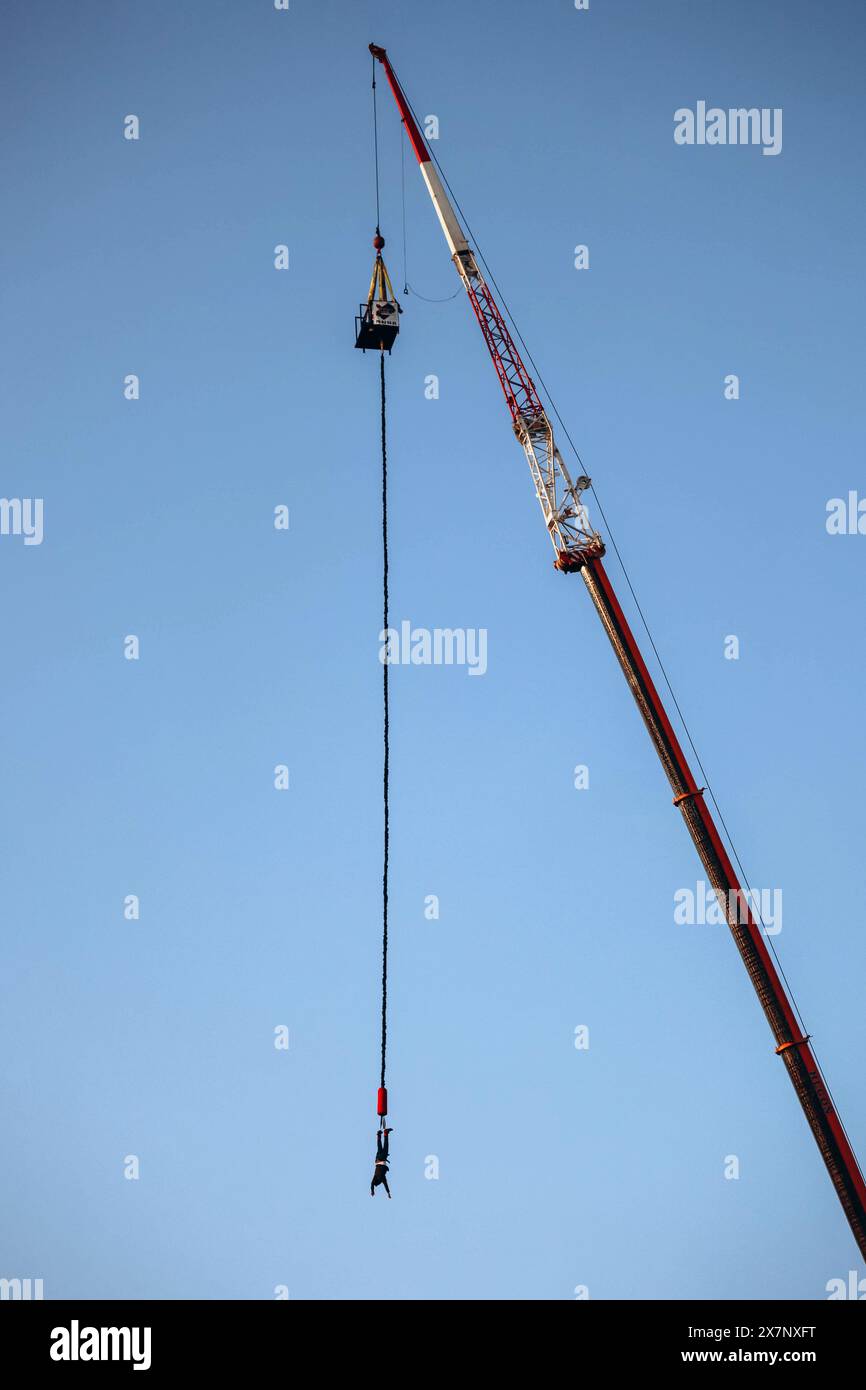Bungee jumping from a great height while connected to a large elastic ...