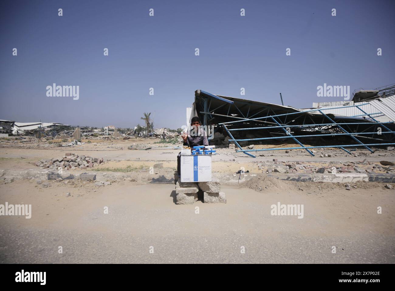 Displaced Palestinians walk between buildings destroyed in Israeli ...