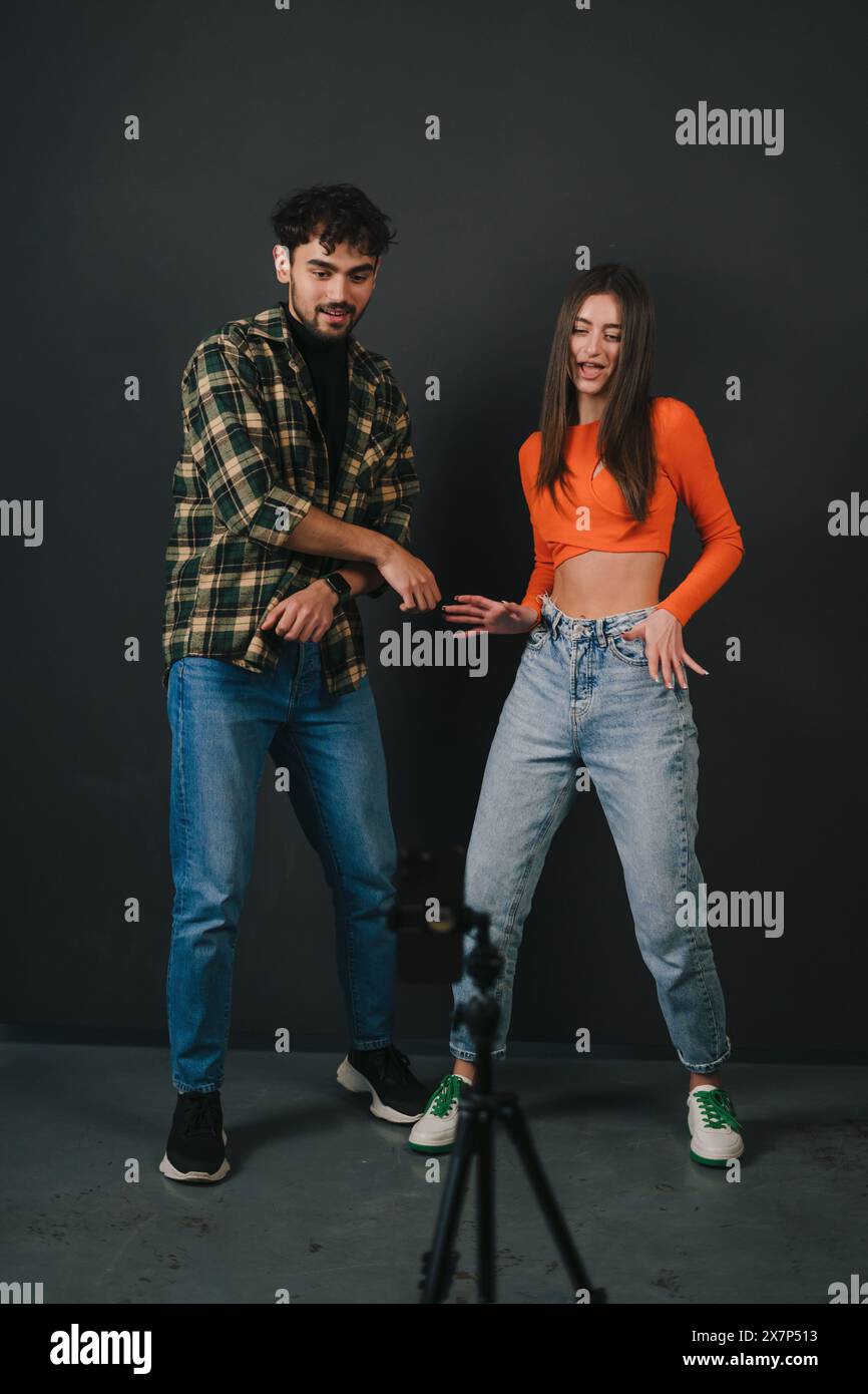 Happy young funny influencer couple enjoy dancing together recording a ...