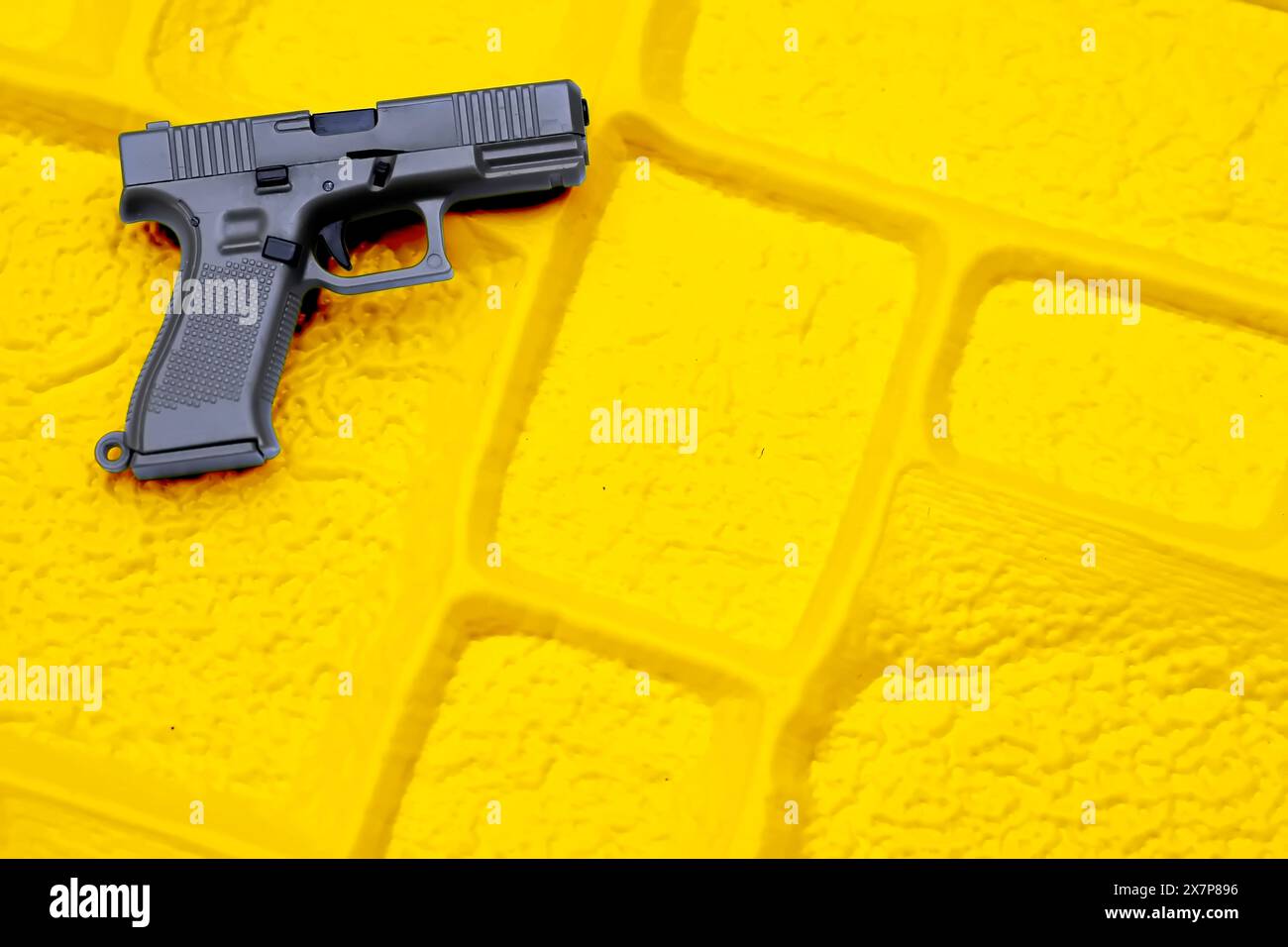 Weapon. Gun pistol on golden corrugated surface Stock Photo - Alamy