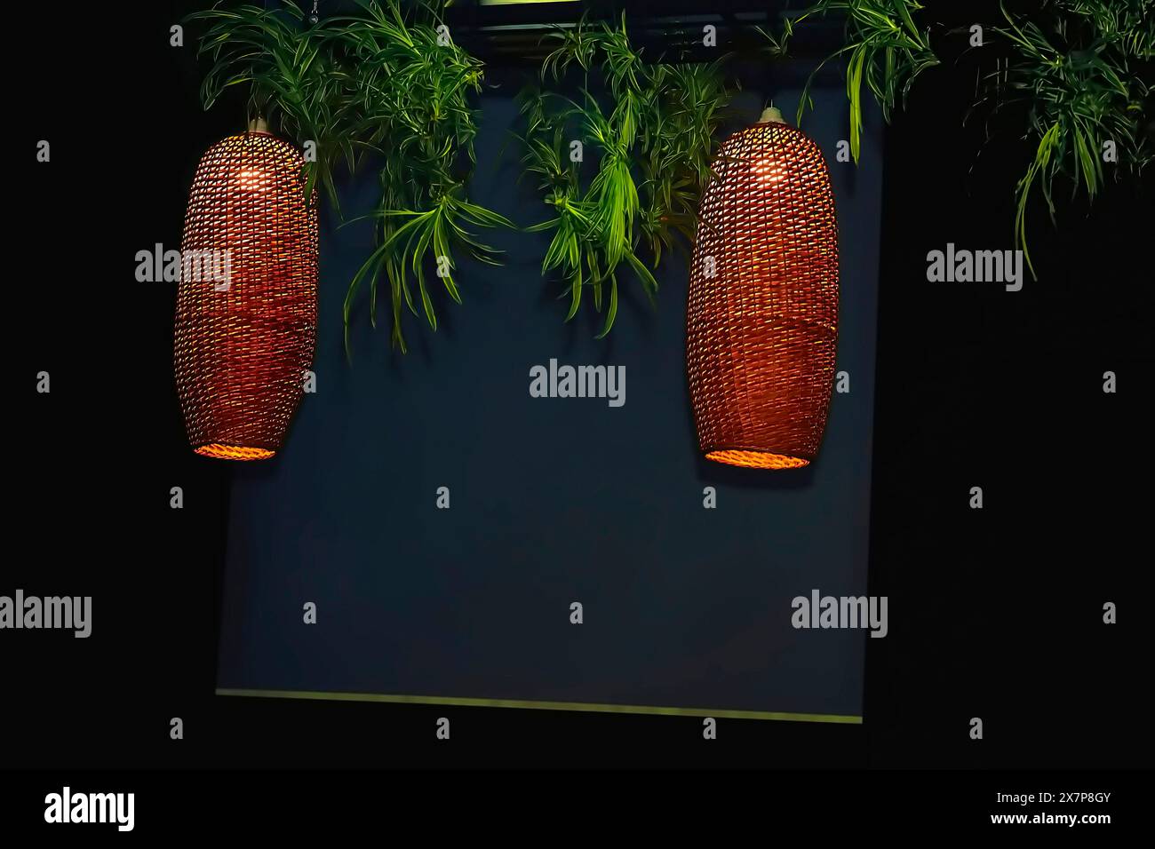 Glowing electric lamps in a wicker lampshade at dusk.Board for text ...