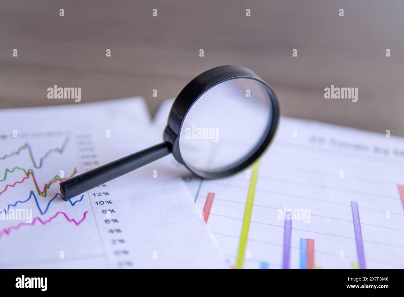 A magnifying glass on a bar graph and line graph. Business and finance ...