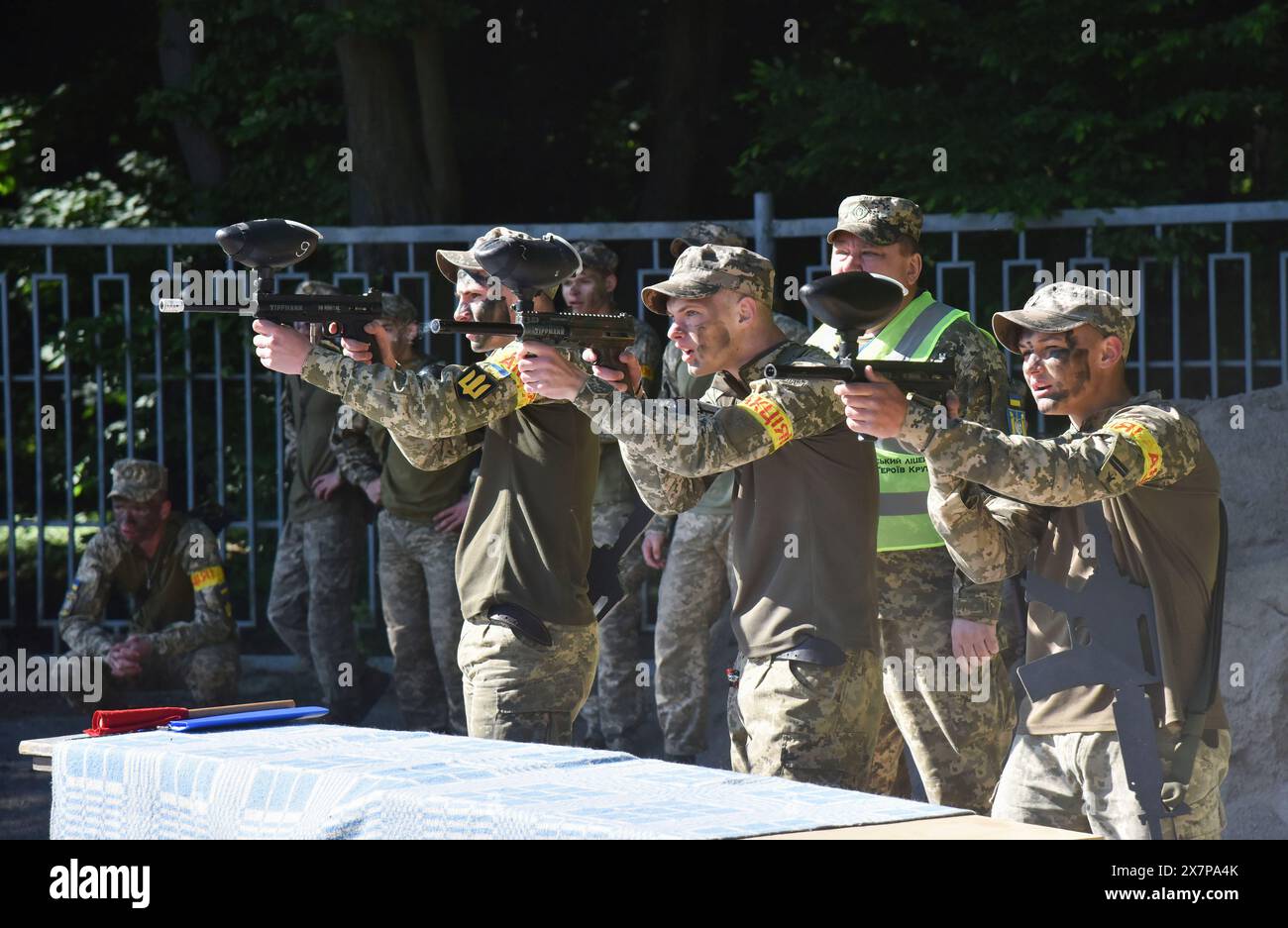 Cadets shoot with paintball guns while passing a line of obstacles at ...