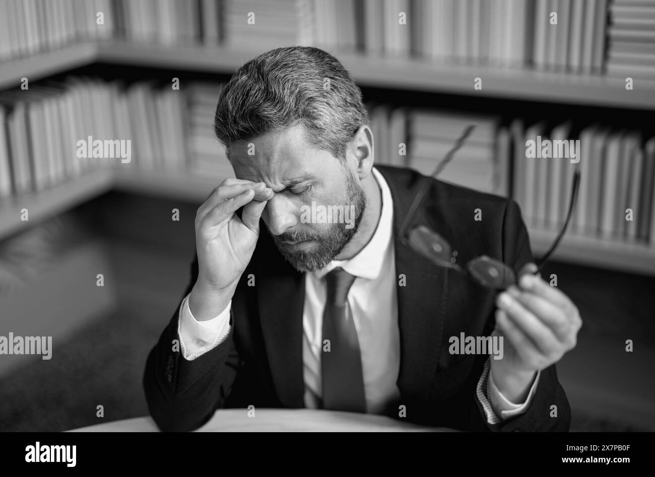 Headache, tiredness and stress. Man in suit uses a laptop, is tired got ...