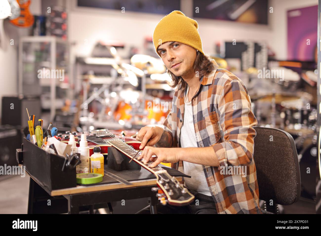 Guy repairing an acoustic guitar in a music instruments workshop Stock ...