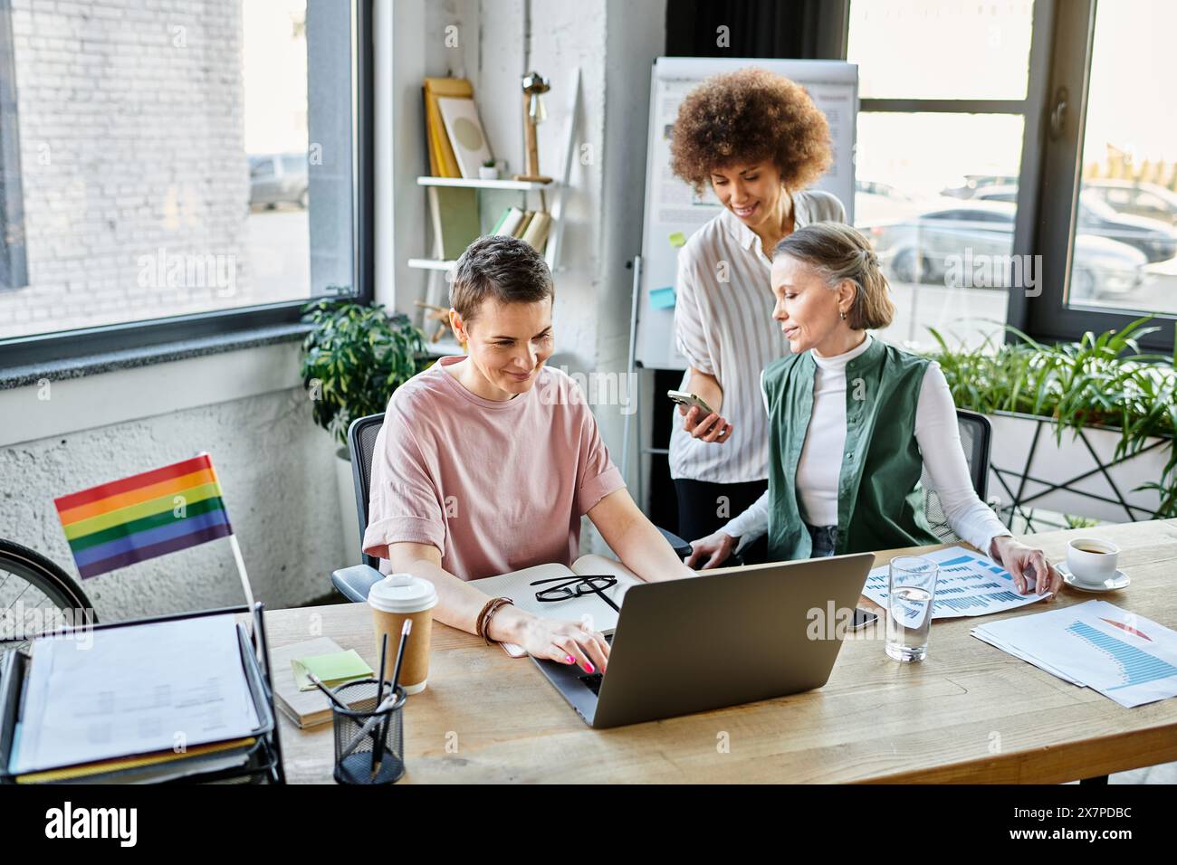 Three hard-working women collaborate at a table in a modern office ...