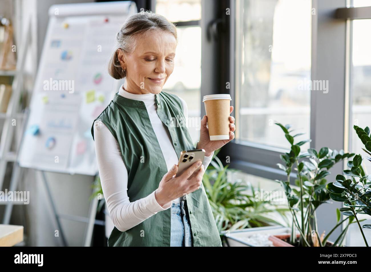 A woman multitasks coffee and phone in a busy office Stock Photo - Alamy
