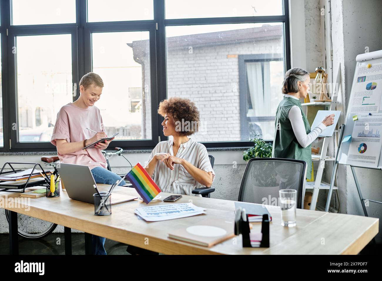 Cheerful diverse female professionals working together on their project ...