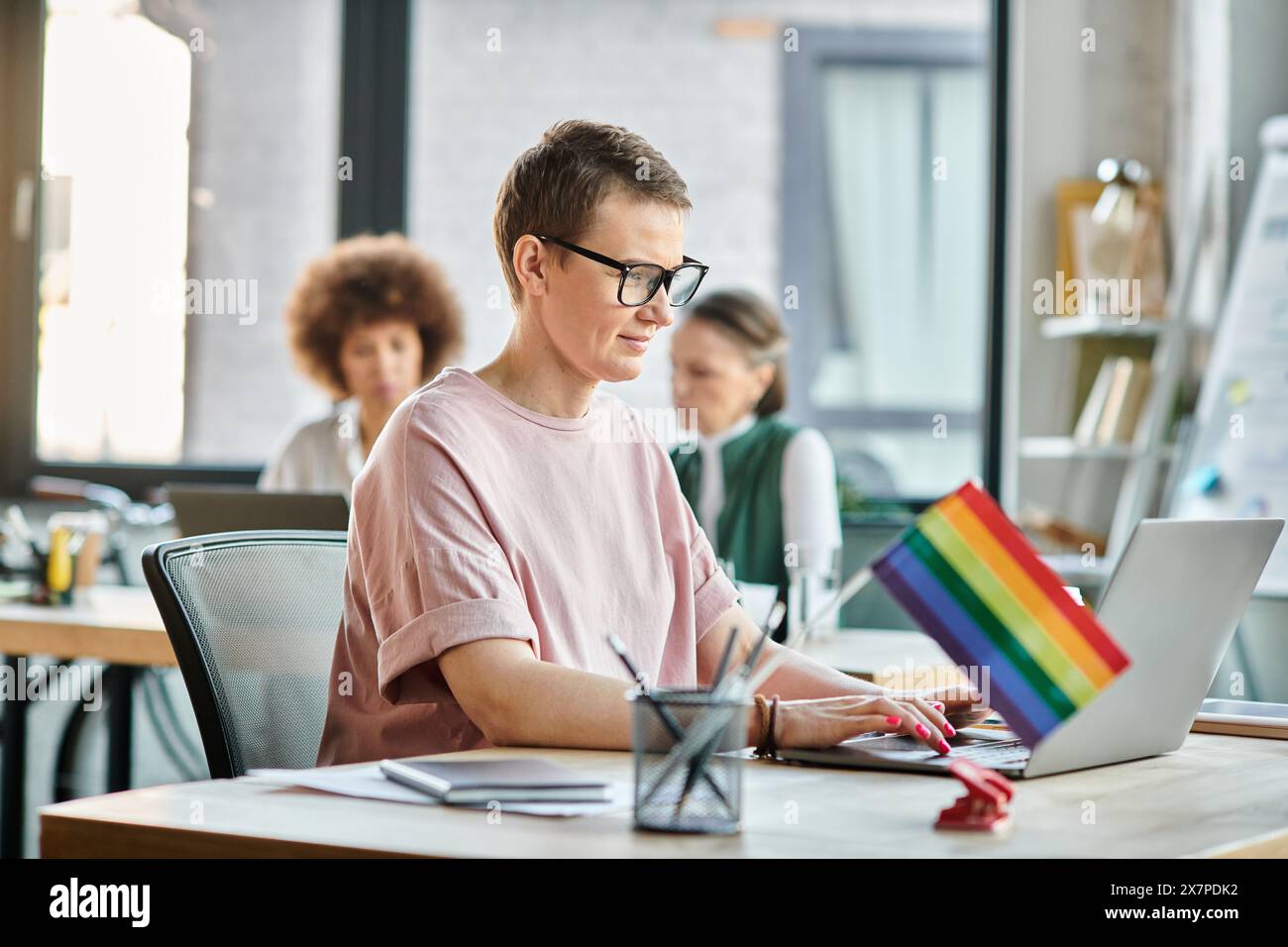 Appealing woman engrossed in work, with a laptop in front of her, with ...