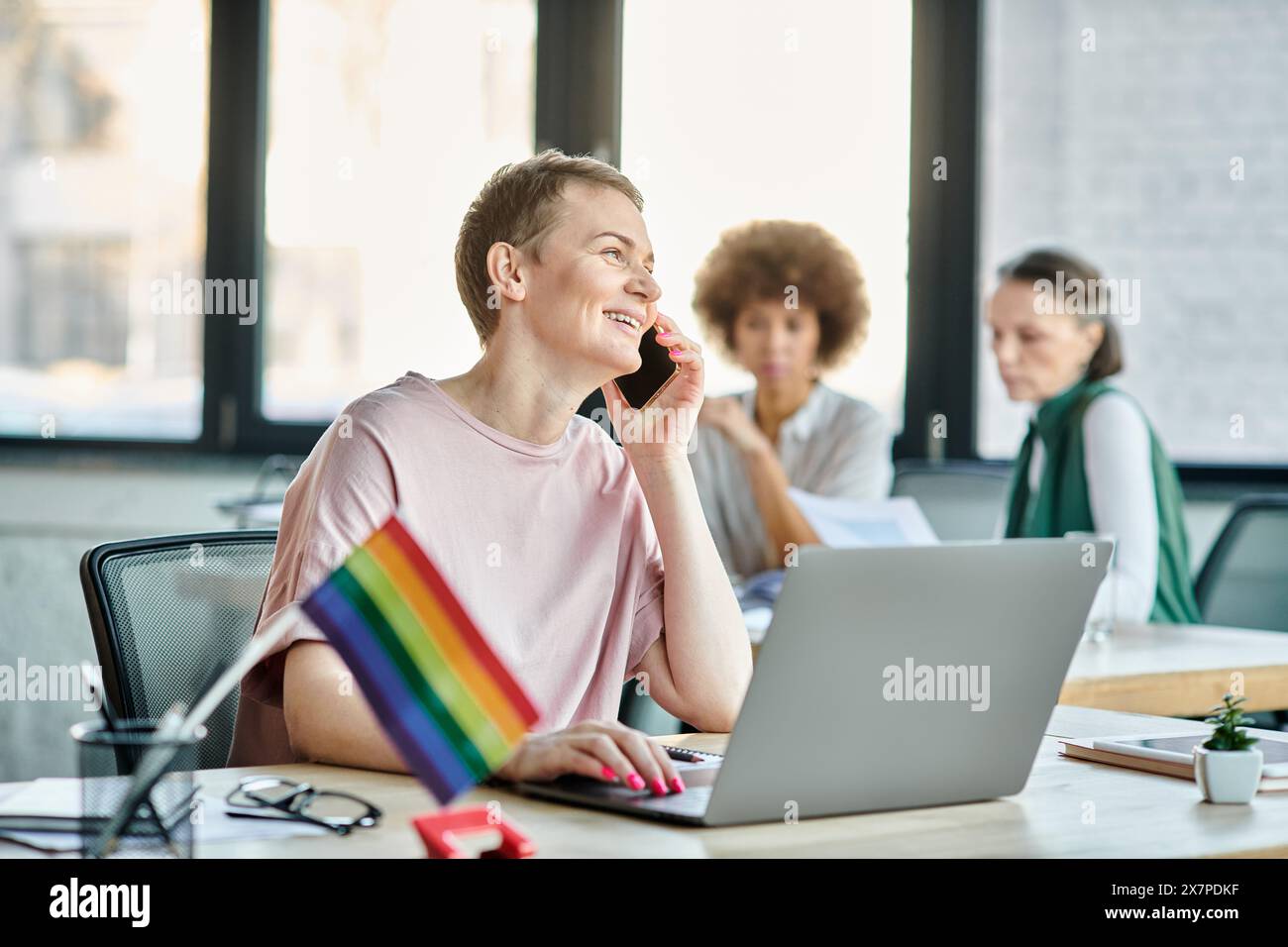 Jolly woman engrossed in work, with a laptop in front of her, with her ...