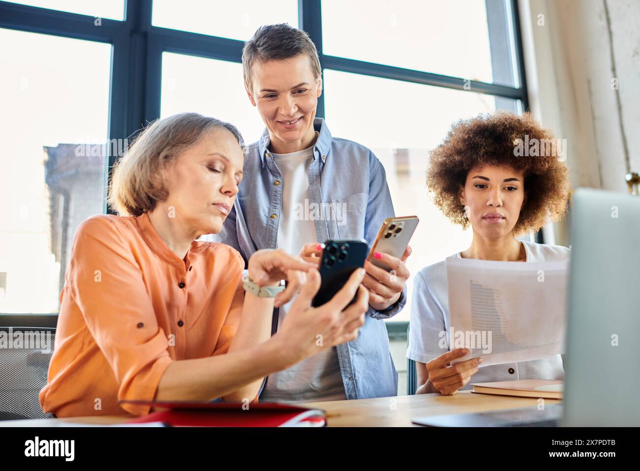 A group of female professionals, working together on a project, holding ...