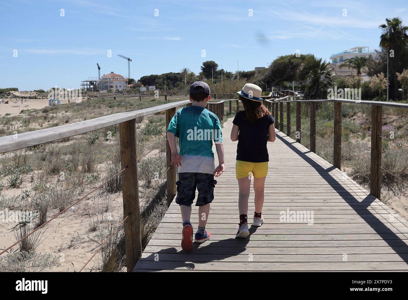 two child sibling walking and talking together friendly outdoors ...