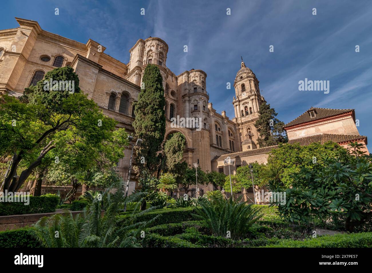 A glimpse of the Cathedral of Malaga, Spain, surrounded by greenery ...