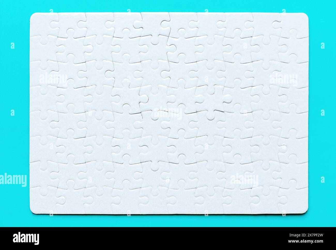 Close-up of a blank rectangular jigsaw puzzle isolated on light blue ...