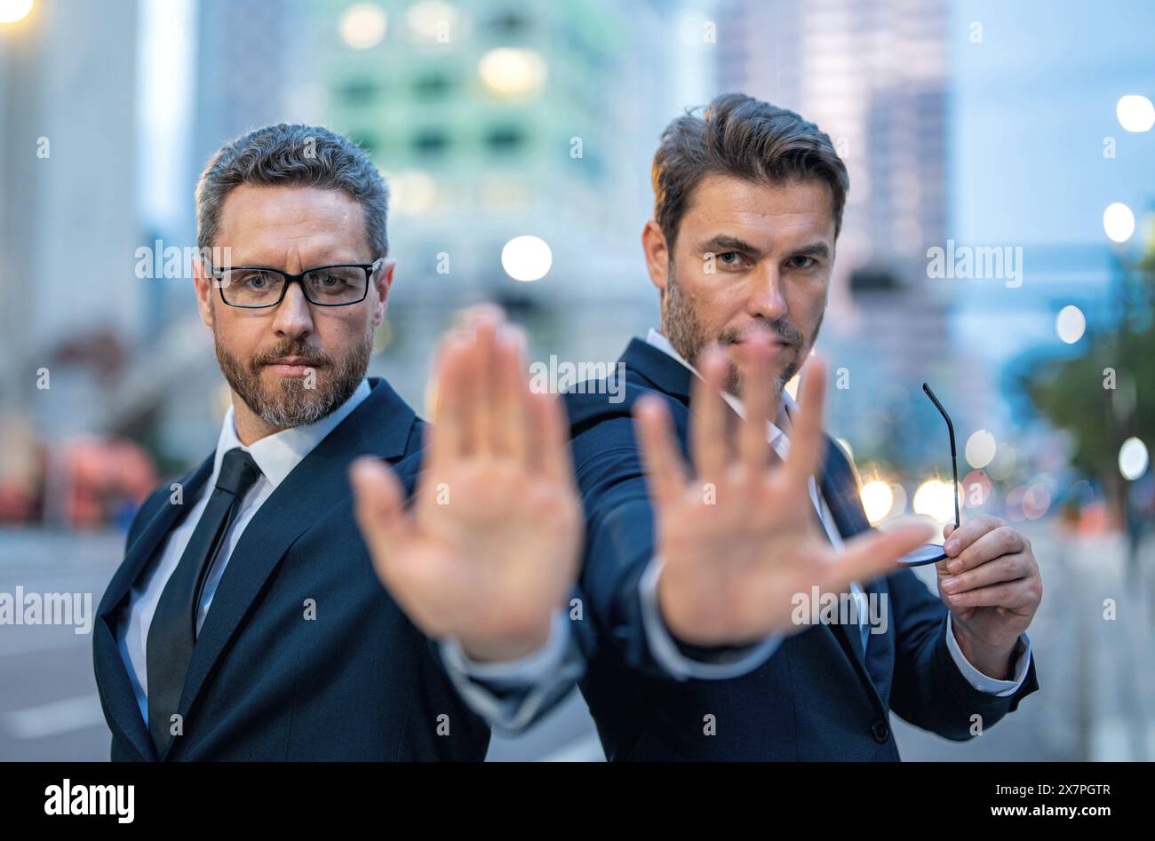Crisis, risk. Two handsome business men in suit doing stop sing with ...