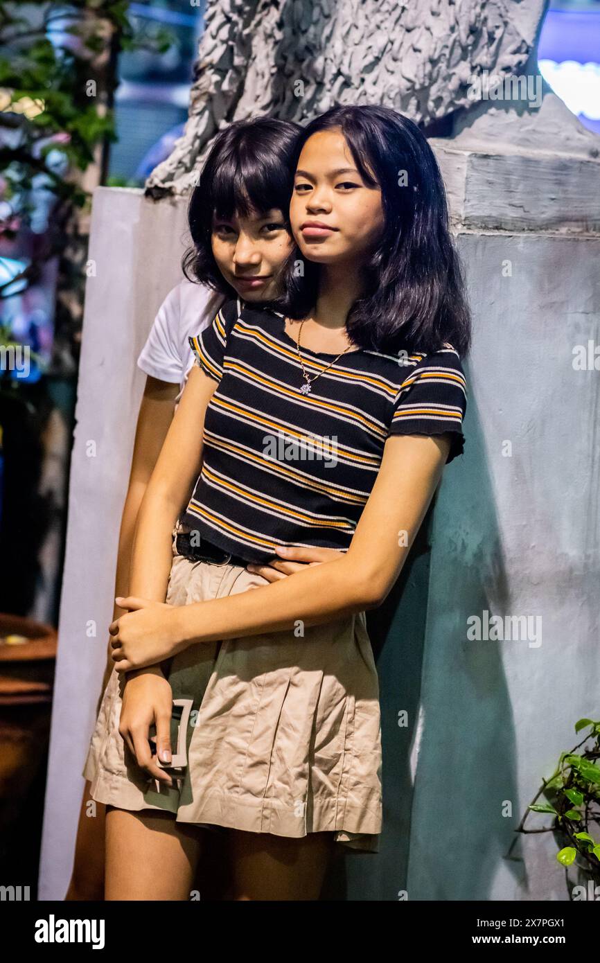 Two young filipino girlfriends hug outside Santo Nino de Tondo Church ...