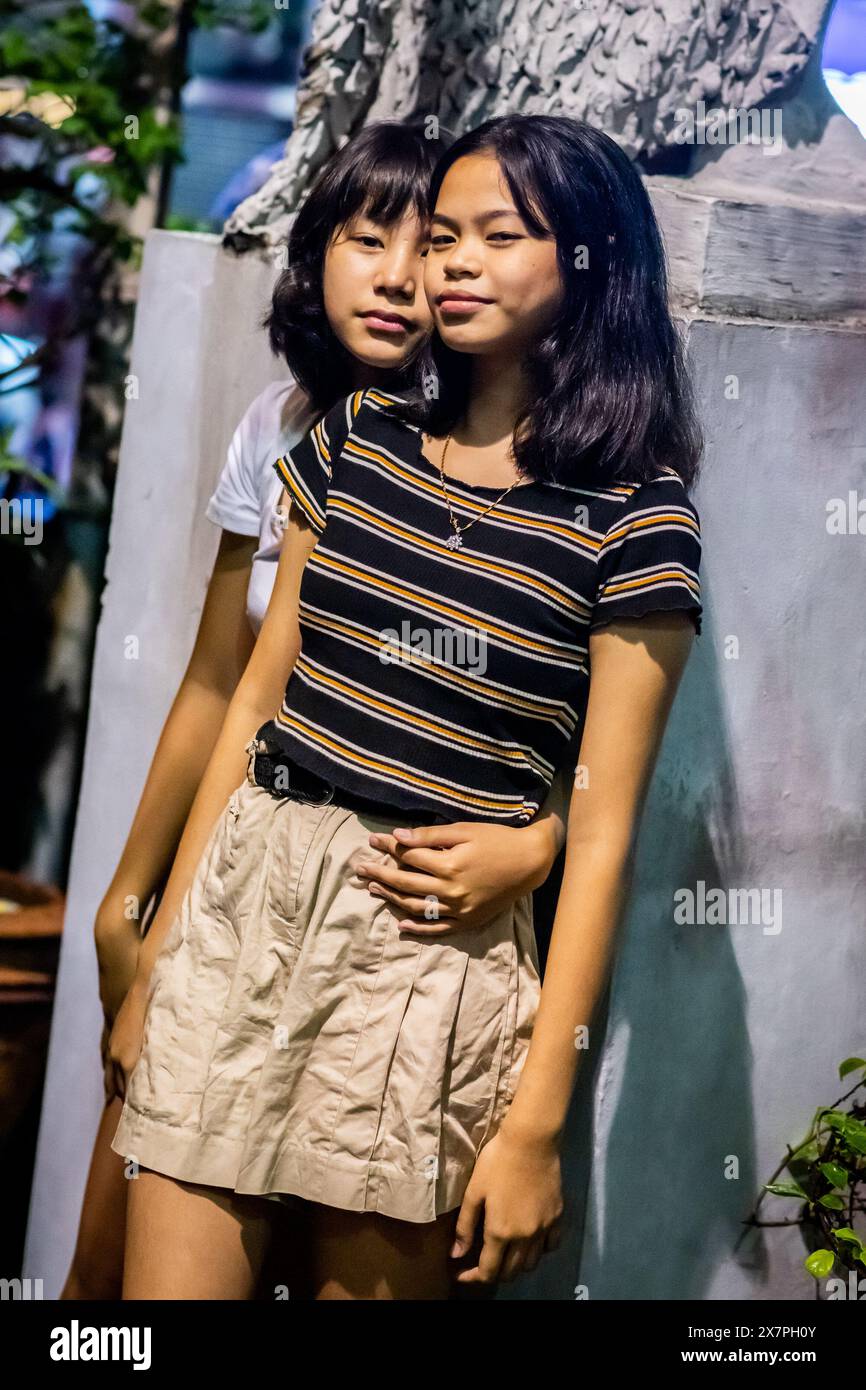 Two young filipino girlfriends hug outside Santo Nino de Tondo Church ...