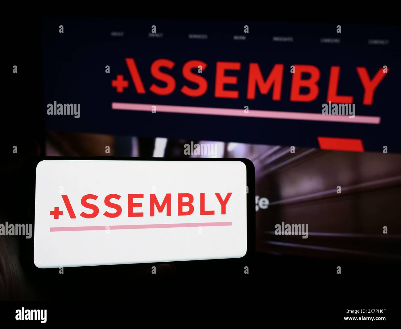 Person holding smartphone with logo of US company advertising PMX ...