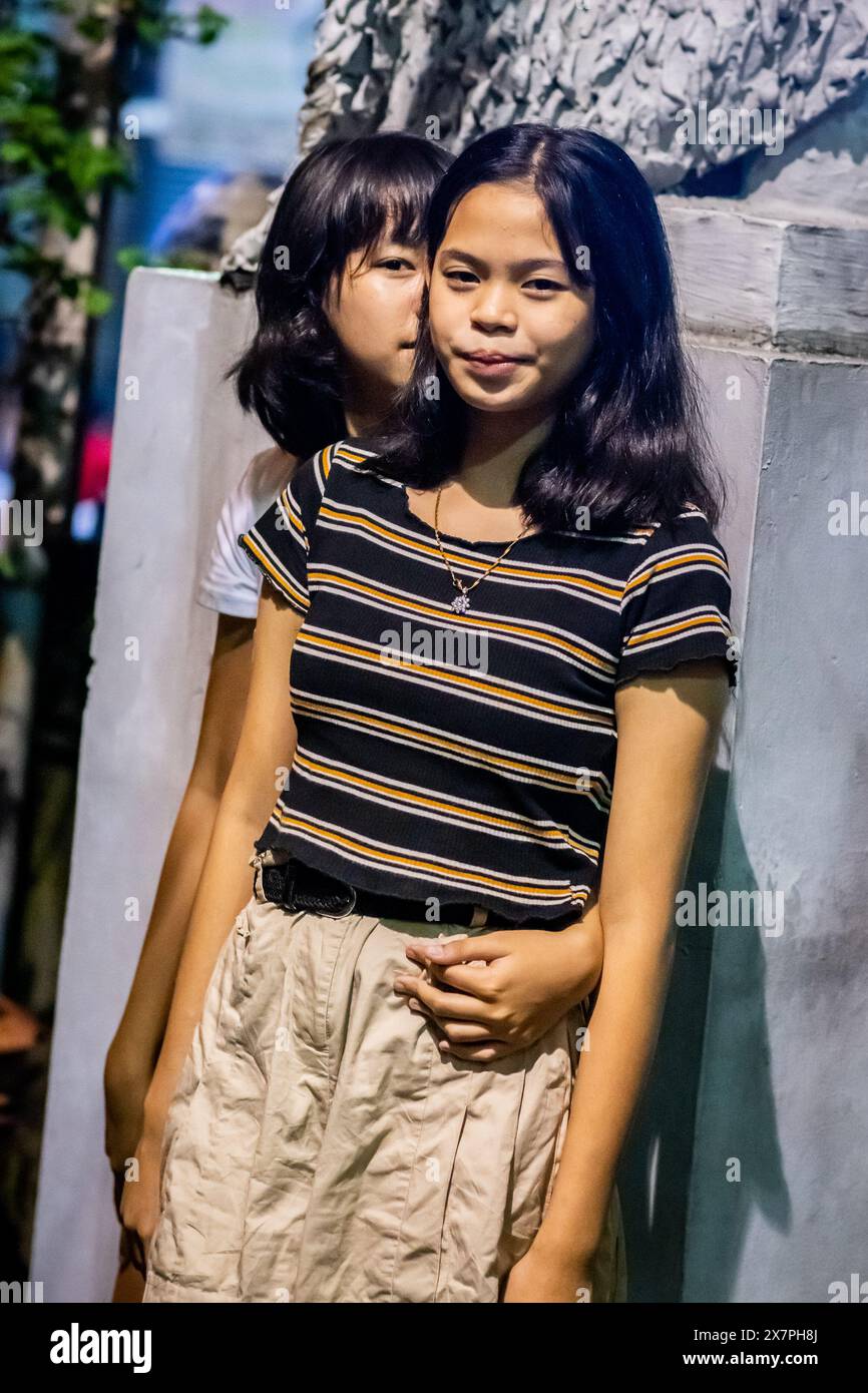 Two young filipino girlfriends hug outside Santo Nino de Tondo Church ...