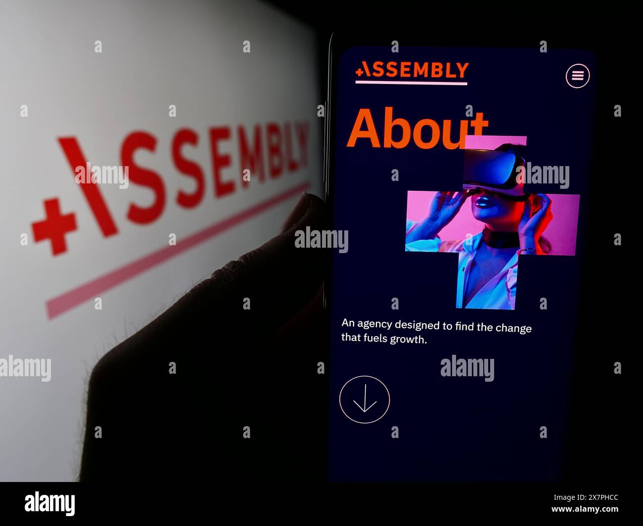 Person holding cellphone with webpage of US company advertising PMX Agency LLC (Assembly Global ...