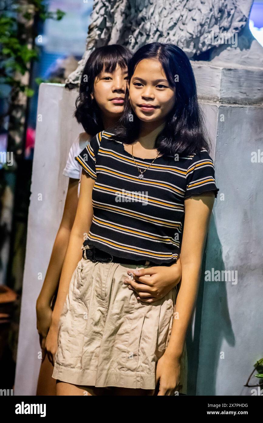 Two young filipino girlfriends hug outside Santo Nino de Tondo Church ...