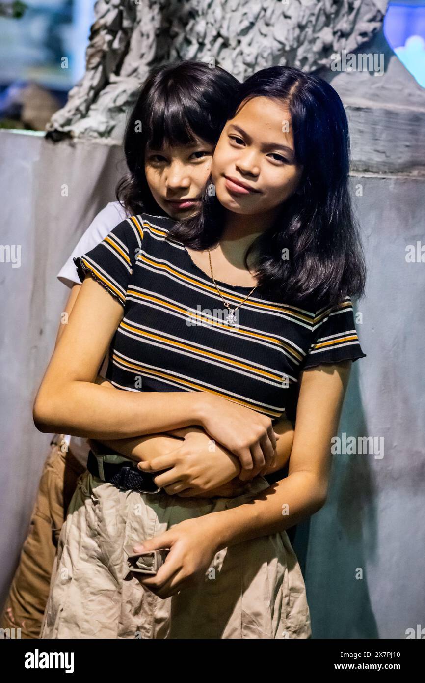 Two young filipino girlfriends hug outside Santo Nino de Tondo Church ...