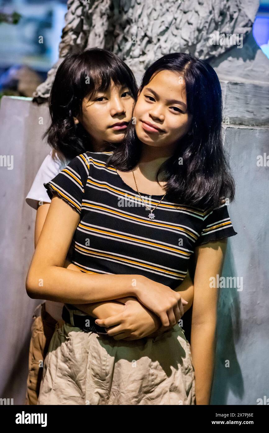 Two young filipino girlfriends hug outside Santo Nino de Tondo Church ...