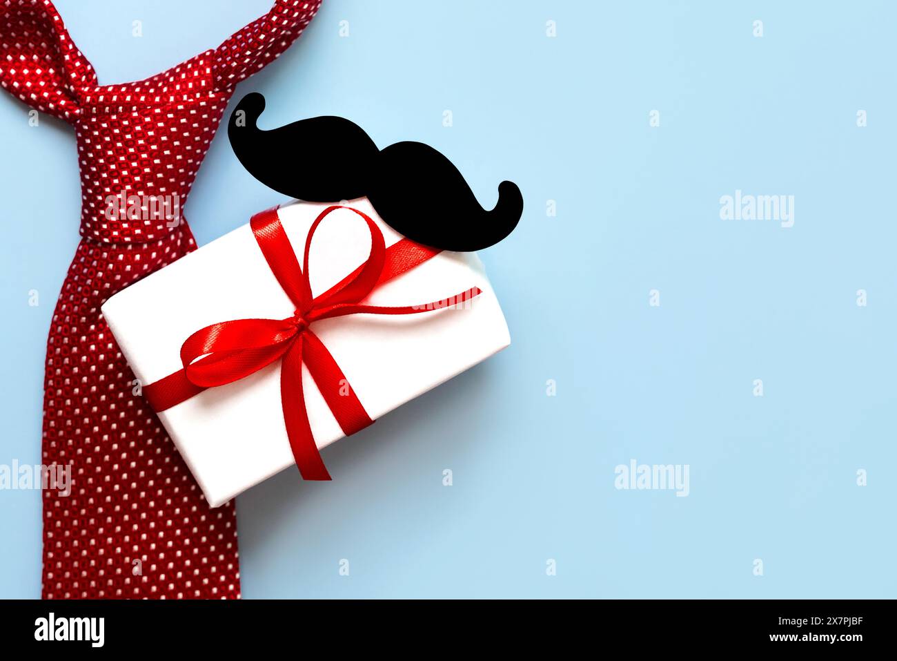 Happy Father's Day. Top view of necktie, mustache and gift box with ...