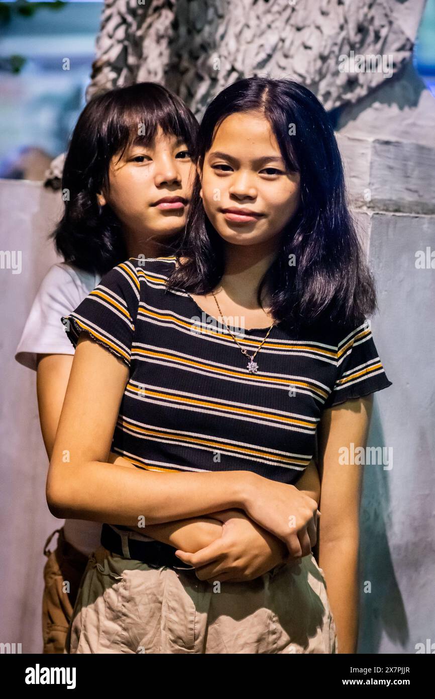 Two young filipino girlfriends hug outside Santo Nino de Tondo Church ...