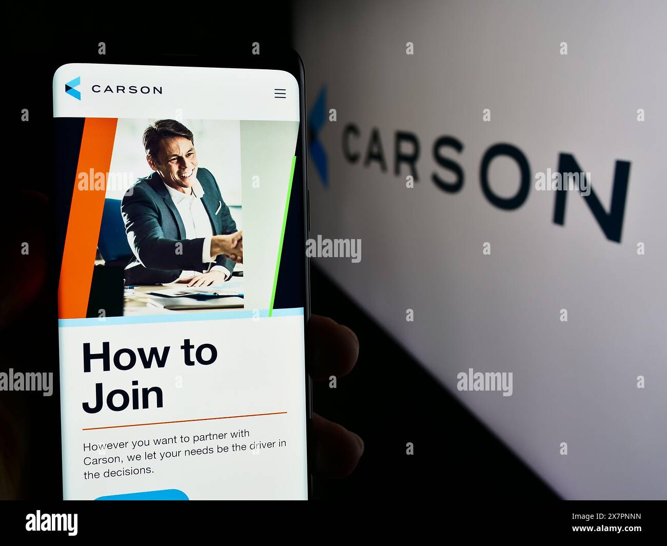 Person holding cellphone with webpage of US investment advisory company ...