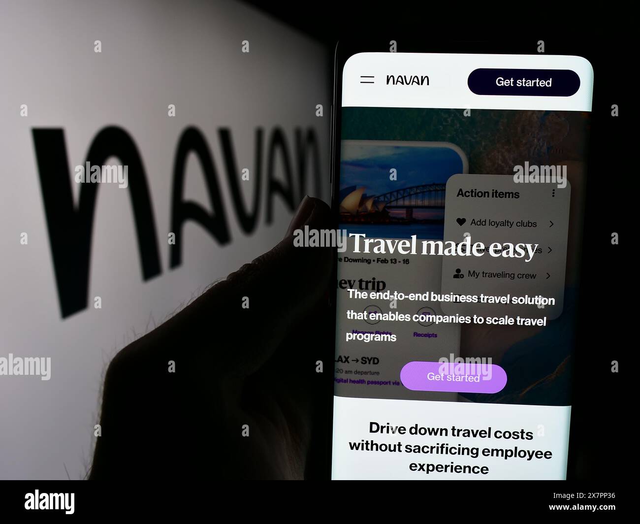 Person holding cellphone with webpage of US travel management software ...