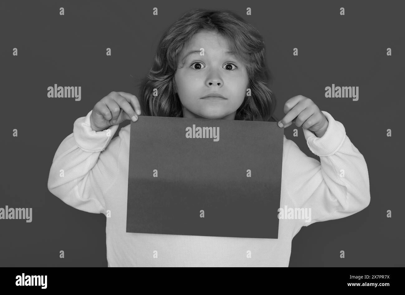Funny child with sheet of paper, isolated on yellow background ...