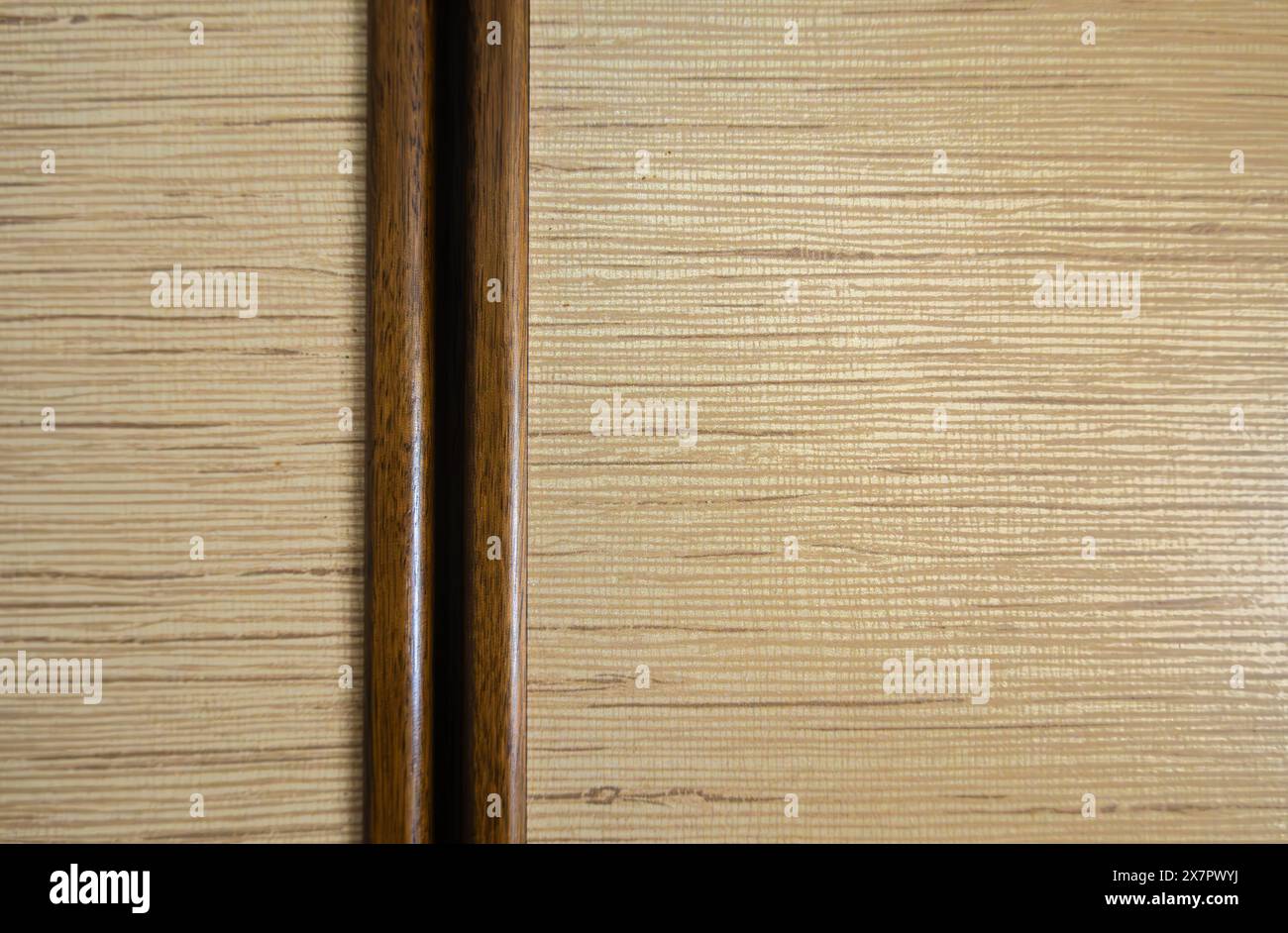 A light-colored wooden panel with horizontal grain pattern, divided by ...
