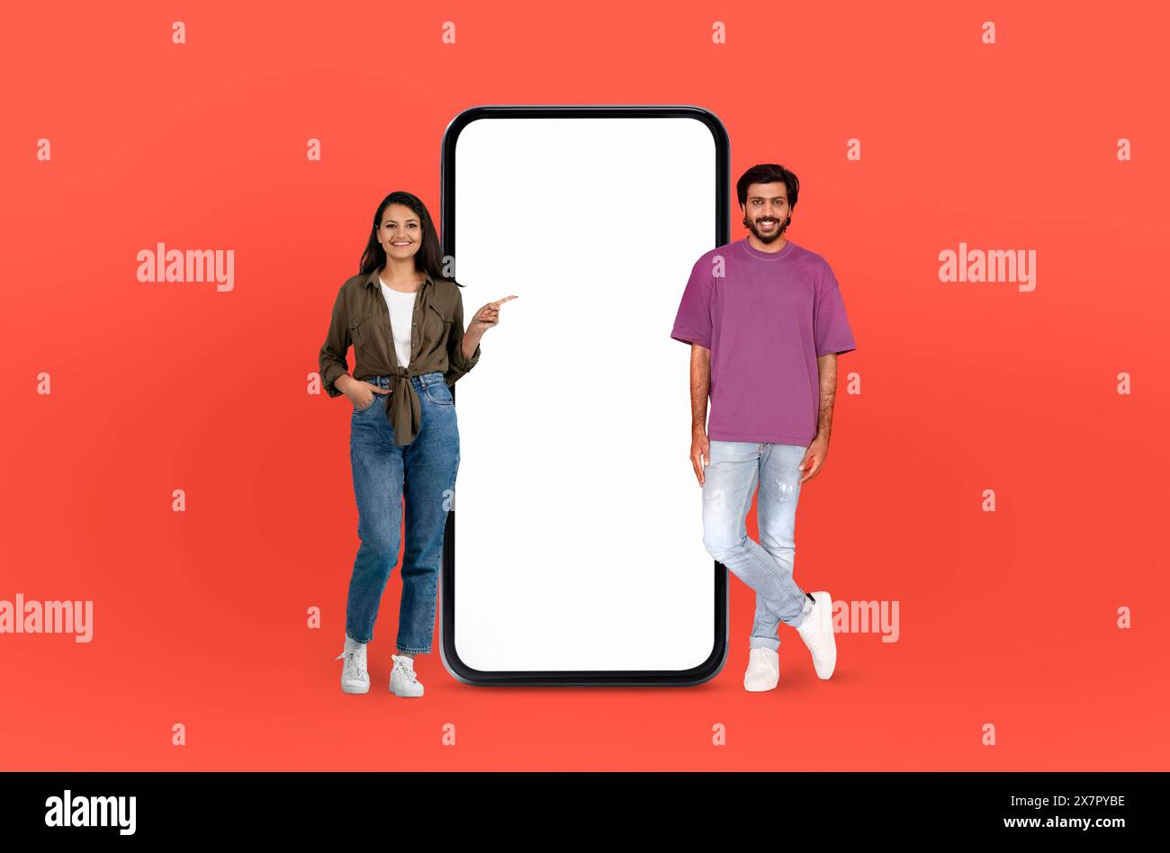 Young indian couple engages with viewers, standing next to smartphone ...