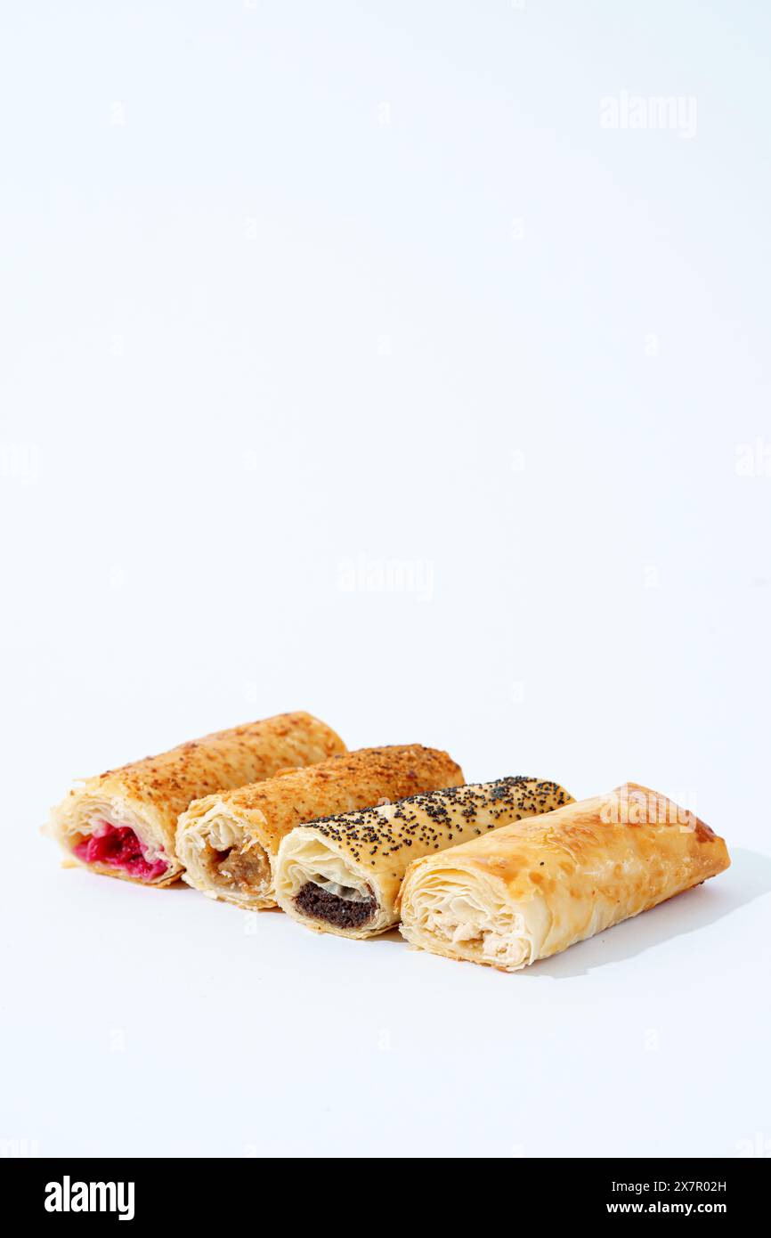 A selection of flaky pastry rolls with various fillings, garnished with ...