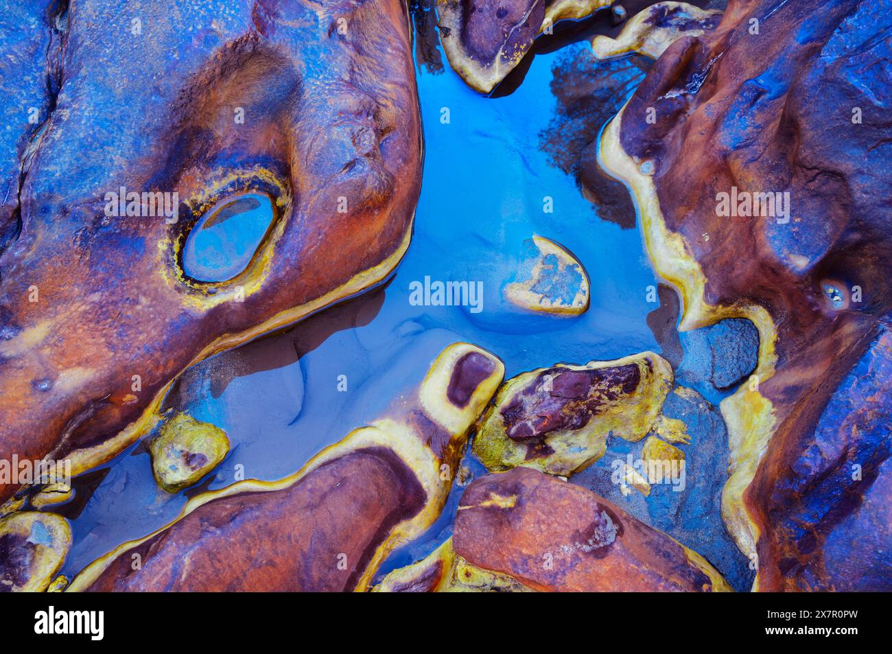 Vibrant blue and rust-colored sedimentary rocks create an abstract ...